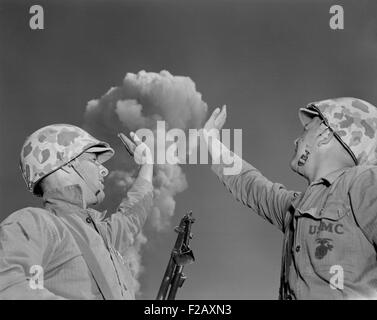 Soldiers pose below an atomic cloud at the Nevada Proving Ground ...
