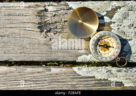 Golden compass on wooden background, closeup Stock Photo - Alamy