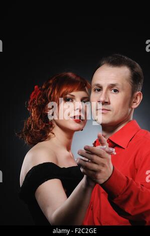 Lovely young Spanish couple dancing in the studio covered in ...