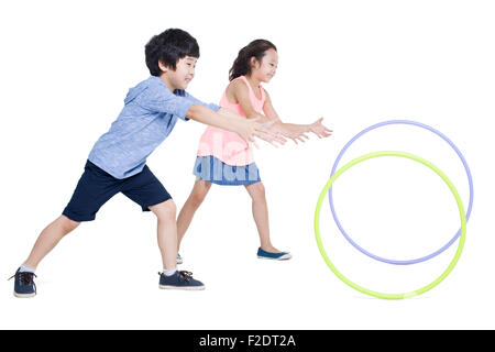 Happy children rolling plastic hoops Stock Photo - Alamy