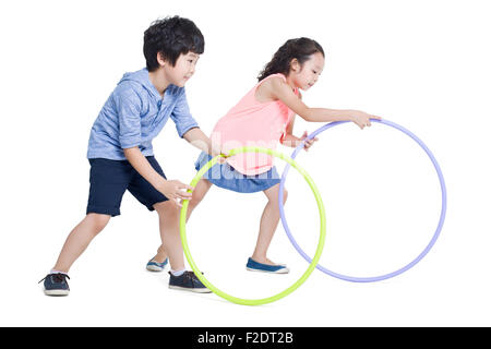 Happy children rolling plastic hoops Stock Photo - Alamy