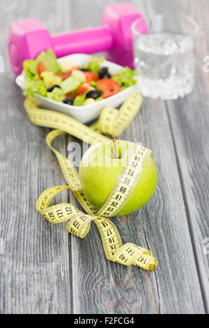 Diet and weight loss concept. Dumbbells, measuring tape, orange fruit ...
