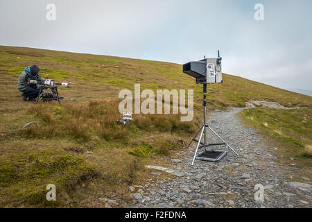 Film crew preparing a large expensive filming drone on the top of a ...