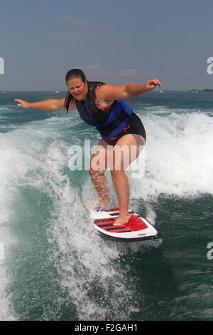 Surf girl on surfboard riding on ocean wave. Woman during surfing on ...