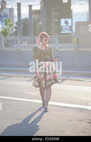 Young redhead woman talking on the phone with open hand doing stop sign ...