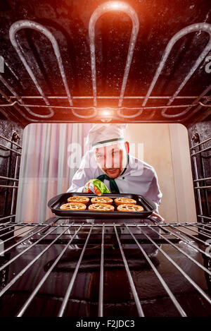 Chef prepares pastries in the oven, view from the inside of the oven ...