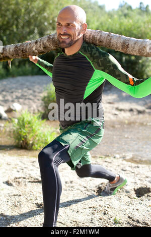 Man doing CrossFit exercise with tree trunk Stock Photo - Alamy