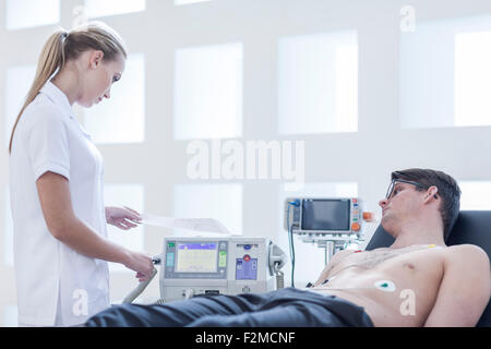 patient getting heart rate monitored with electrocardiogram equipment ...