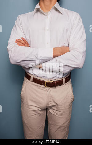 Happy man with arms crossed standing in front of wall Stock Photo - Alamy