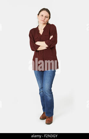 full length of positive woman in satin slip dress standing with red ...