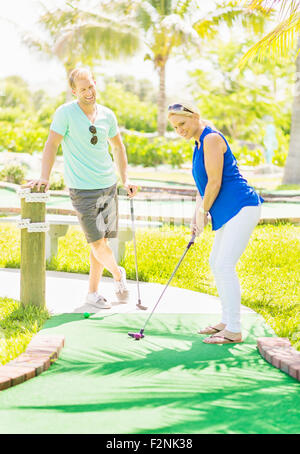 Caucasian couple playing miniature golf Stock Photo - Alamy