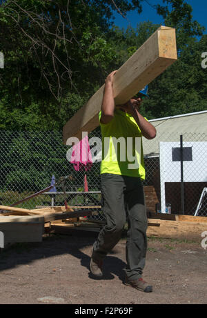 Carpenter carrying beam Stock Photo - Alamy