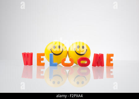 Welcome sign with two smileys on white background Stock Photo - Alamy