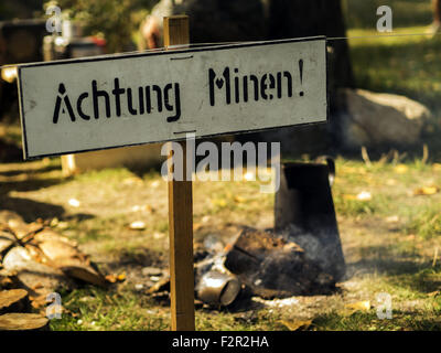 a skull sign with the inscription caution mines in German "Achtung ...