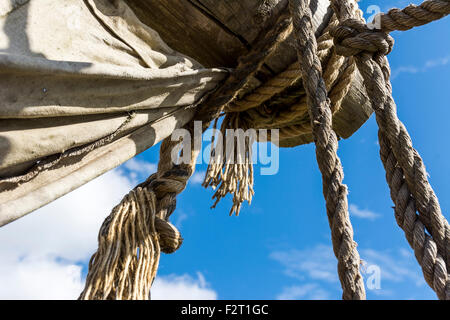 Old ragged sailing rigging an ancient sailing vessel against cloudy sky ...