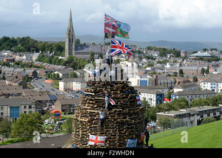 Nationalist youths standing on a large bonfire made from wooden pallets ...