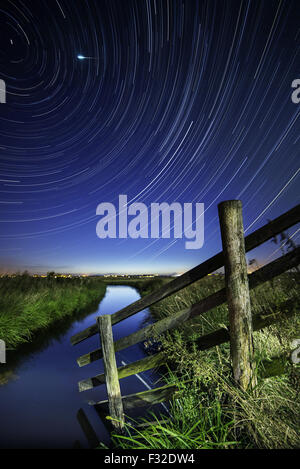View of cattle fencing and water-filled ditch on coastal grazing marsh ...