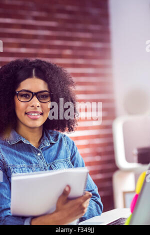 Casual businesswoman looking at reports Stock Photo - Alamy