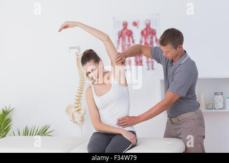 Doctor stretching a young woman arm Stock Photo - Alamy