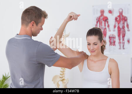 Doctor stretching a young woman arm Stock Photo - Alamy