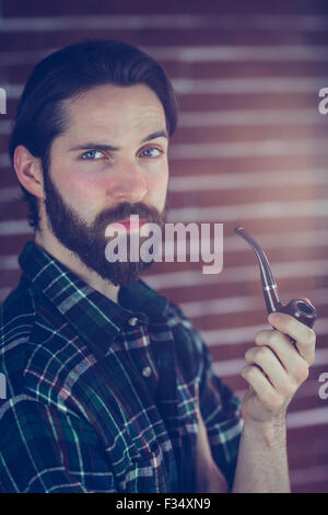 Portrait of confident hipster smoking pipe Stock Photo - Alamy
