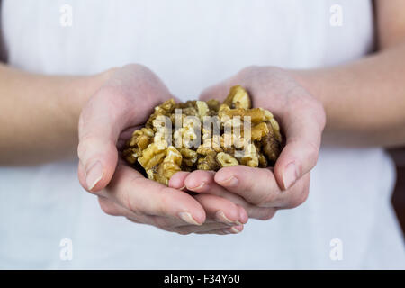 Woman showing handful of walnuts Stock Photo - Alamy