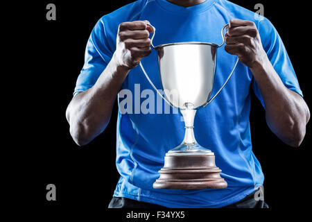 Mid section of sportsman holding trophy Stock Photo - Alamy