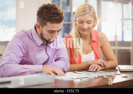 Young business people looking at documents and products standing at the ...