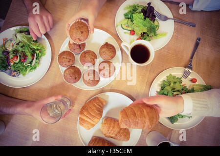 Business people having cakes and bread with salad Stock Photo - Alamy