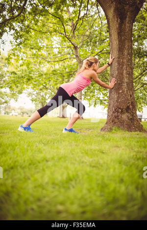 Side view of woman stretching while exercising at park Stock Photo - Alamy