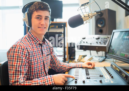 Portrait of radio host using sound mixer in studio Stock Photo - Alamy