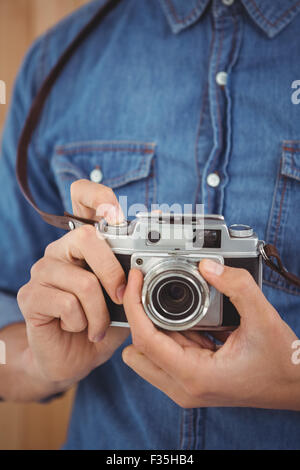 Close-up of a hand adjusting the lens of a projector on a wooden ...