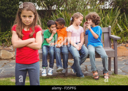 Upset child standing away from group Stock Photo - Alamy