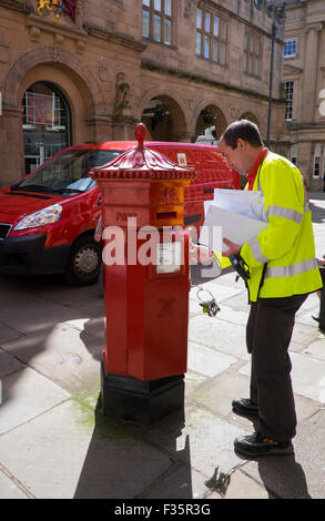 postman collecting letters from red Postbox. Poole UK Stock Photo - Alamy