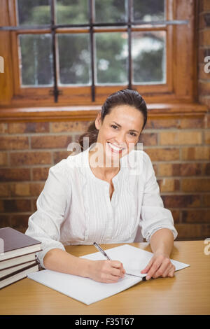 Smiling teacher correcting students work Stock Photo - Alamy