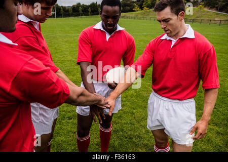 Rugby players putting hands together Stock Photo - Alamy