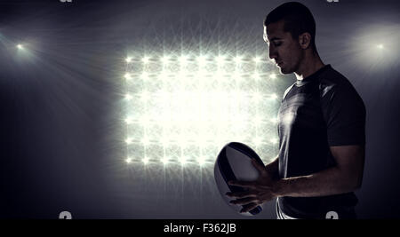 Composite image of calm rugby player thinking while holding ball Stock ...
