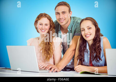 Portrait of a happy students using laptop computer together in ...