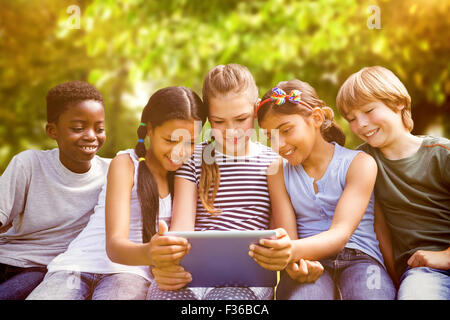 Composite image of children using digital tablet at park Stock Photo ...