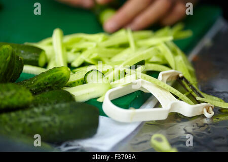 Cook cleans and cuts the cucumber Stock Photo - Alamy