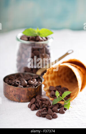 Chocolate ice cream cones decorated with candy, on blue wood table ...
