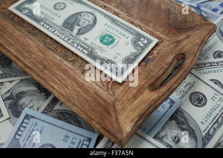 money on a wooden tray, two USD Stock Photo - Alamy