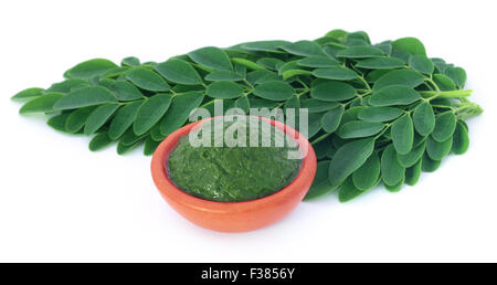 Edible moringa leaves with ground paste over white background Stock ...