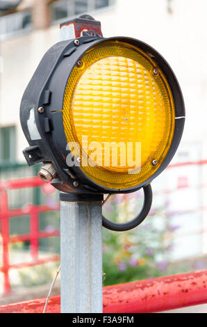 One yellow signal light on an urban background Stock Photo - Alamy