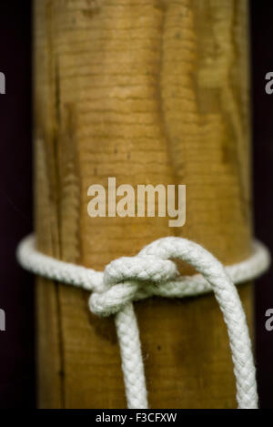 A rope is tied in a knot around a fence post , rope tied knot wood ...