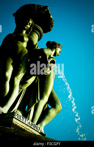 Water fountain with sculpture of female pouring water from pot beside ...