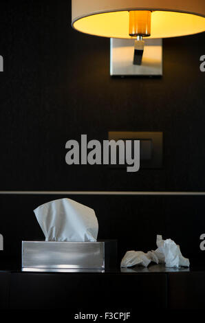 Box with paper tissues and used crumpled napkins on grey background ...