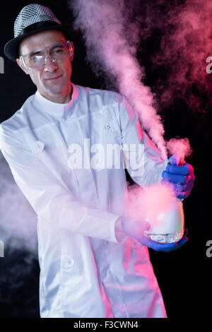 Smiling man scientist with dry ice Stock Photo - Alamy