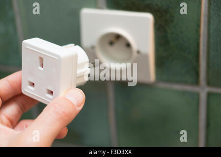 hand putting plug into 3-pin electric socket Stock Photo - Alamy