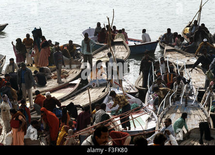 Boats or ferries ferry devotees at the confluence of the Ganges ...